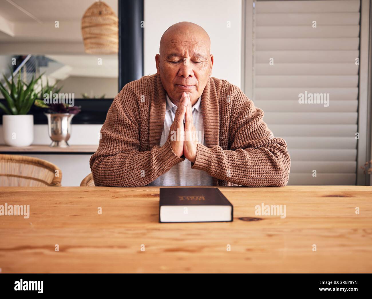 Senior man, bible and praying in home with faith, religion and ...