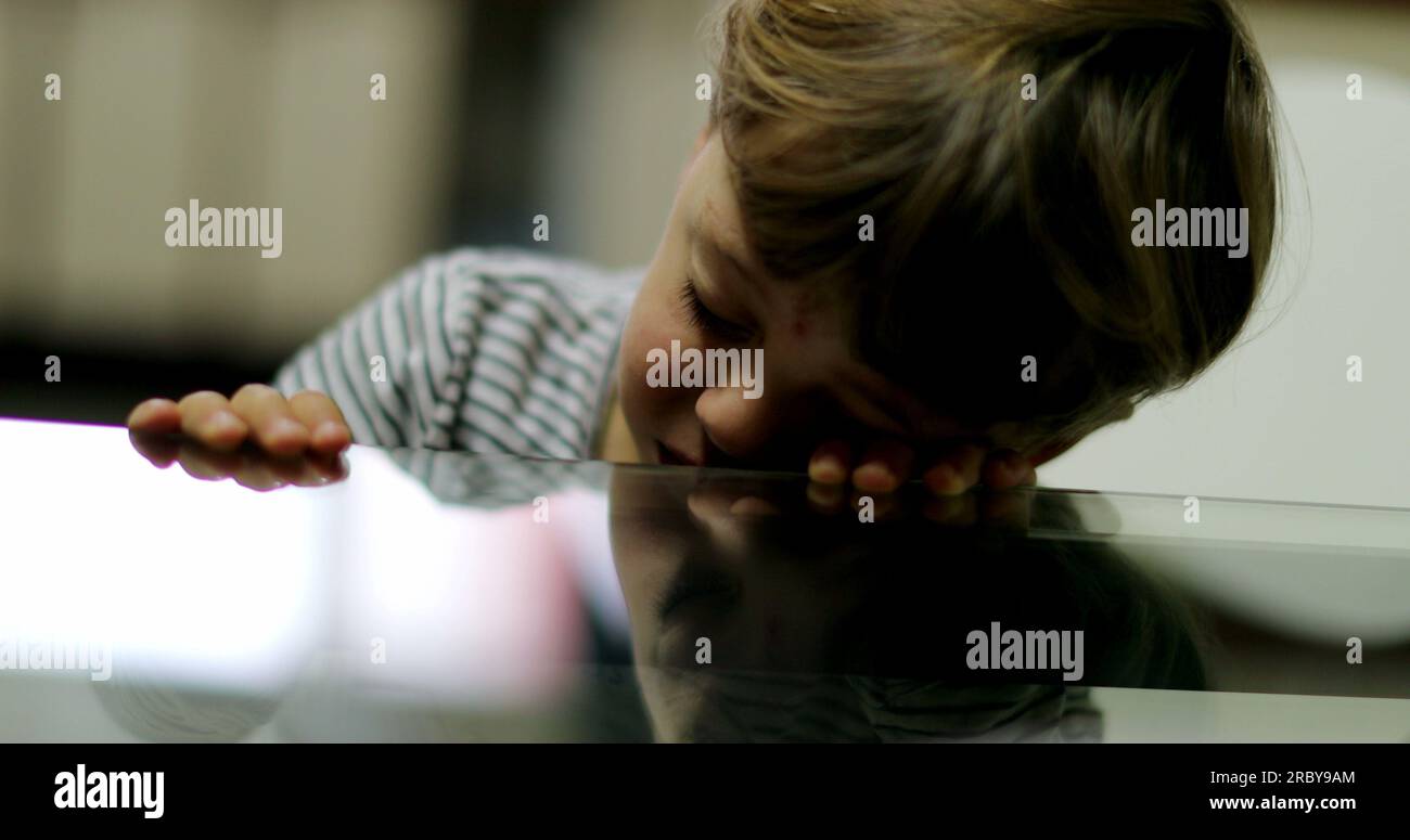 One sleepy child leaning on table falling asleep Stock Photo - Alamy