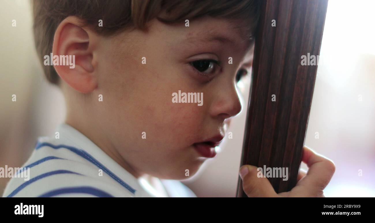 Tearful child hiding underneath table victim kid looking up feeling ...