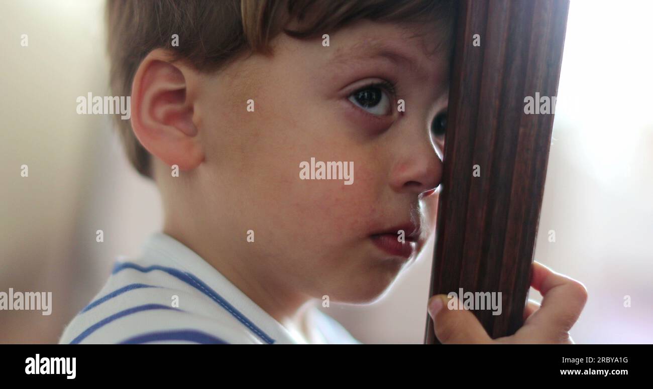 Tearful child hiding underneath table victim kid looking up feeling ...