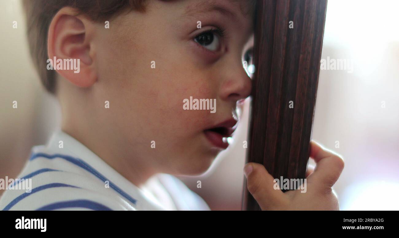 Tearful child hiding underneath table victim kid looking up feeling ...