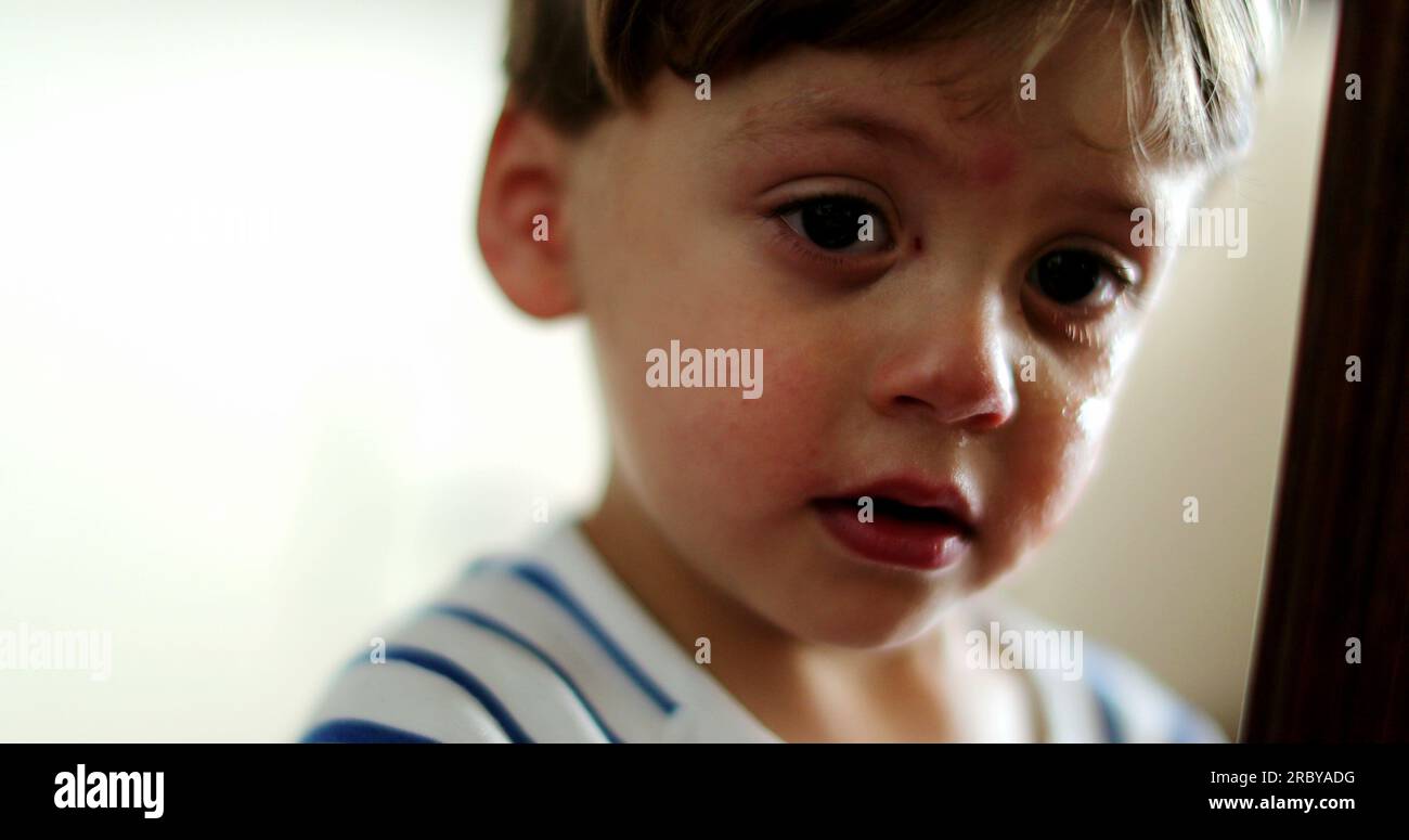 Portrait of sad tearful child face looking at camera Stock Photo - Alamy