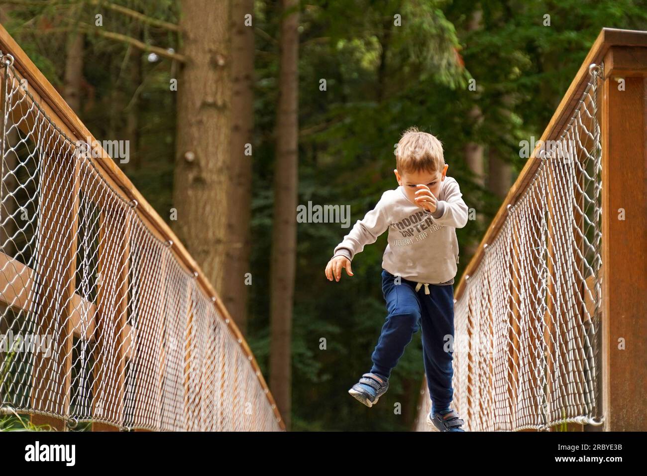 A little boy runs down the path with all his might. A little athlete ...
