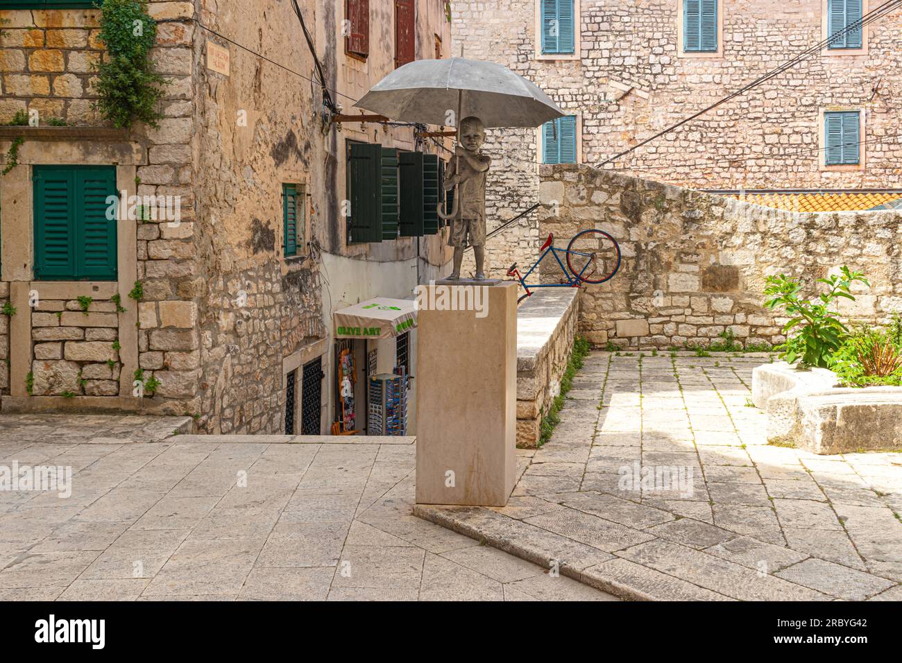Statue of a small male child holding an umbrella is a tourist ...