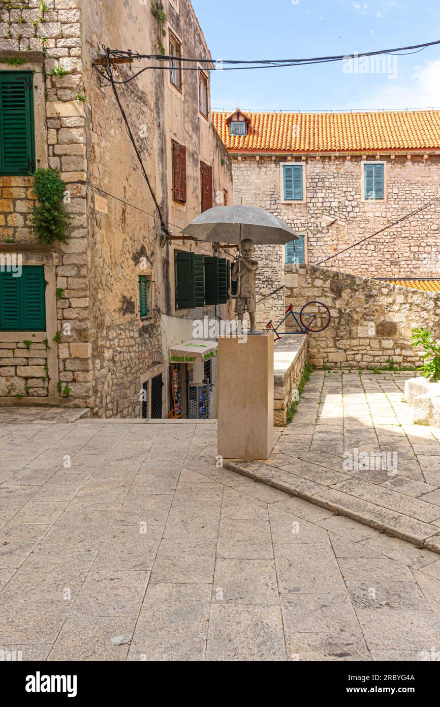 Statue of a small male child holding an umbrella is a tourist ...