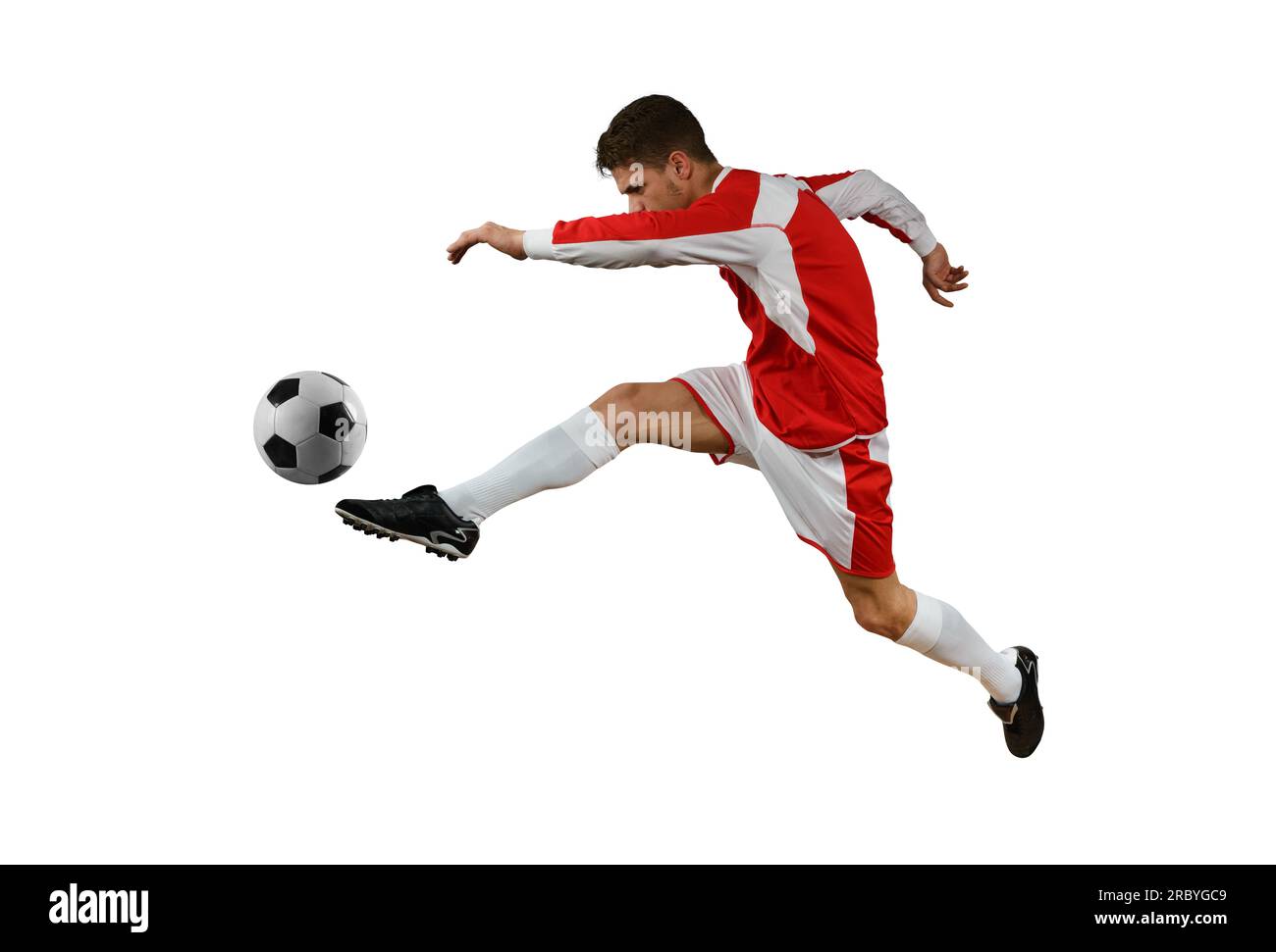 Soccer player kicks the soccerball in the air by jumping Stock Photo ...