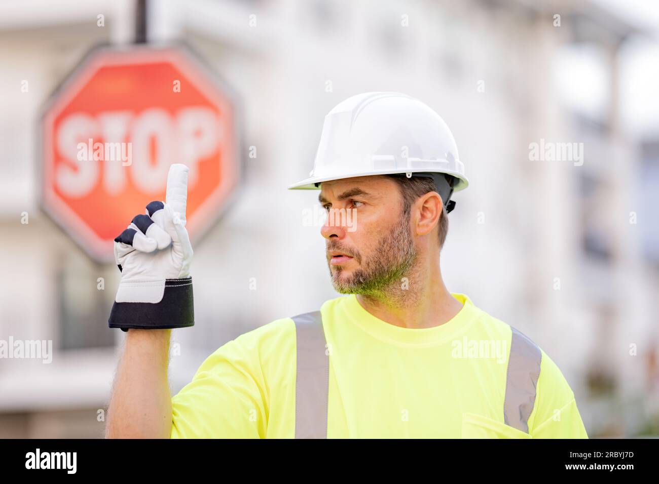 Worker builder in hard hat with stop road sign. Builder with stop ...
