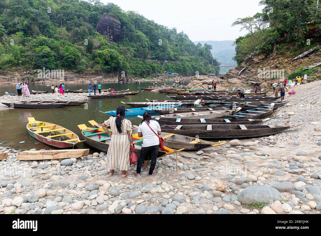 Indian tourists looking at the traditional wooden boats on a shore of a ...