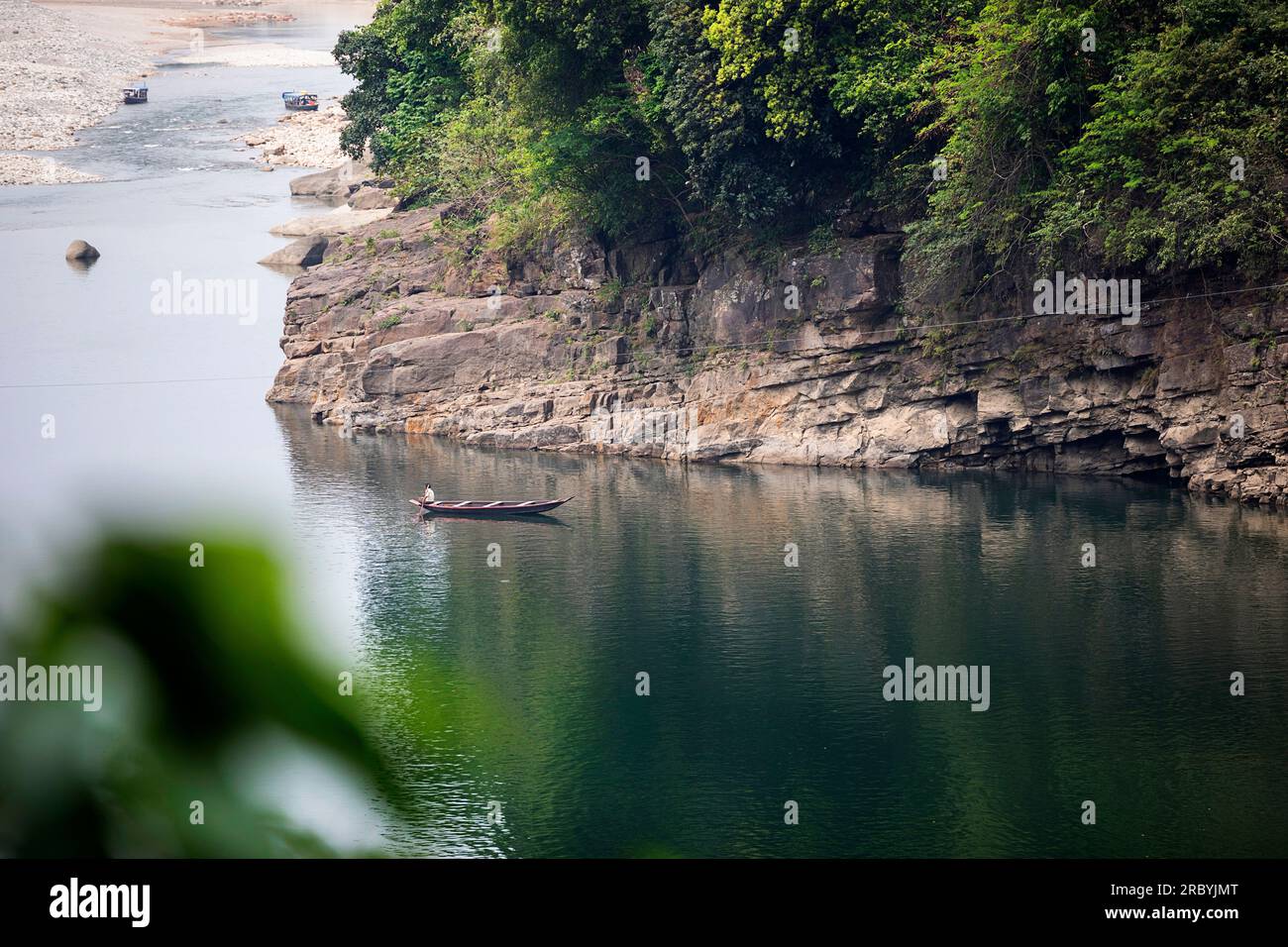 Local boatman on traditional wooden boat on Umngot or Dawki river in ...