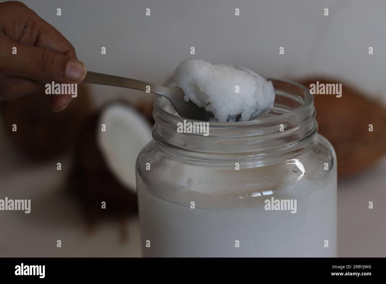 Frozen coconut oil in a glass bottle taken from refrigerator. Coconut ...