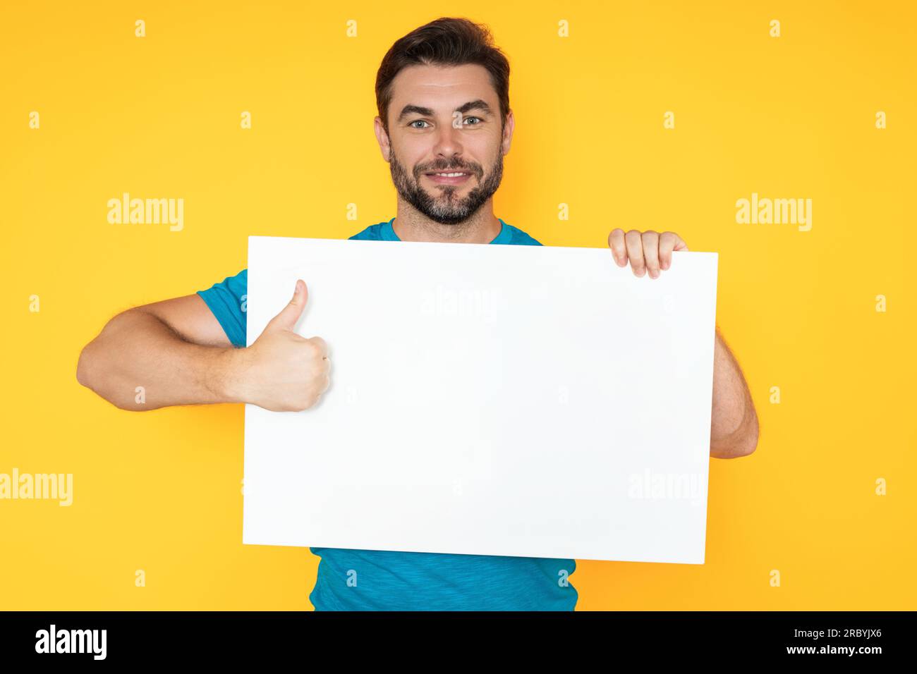 Man with thumb up and blank banner ad, on studio background. Portrait ...