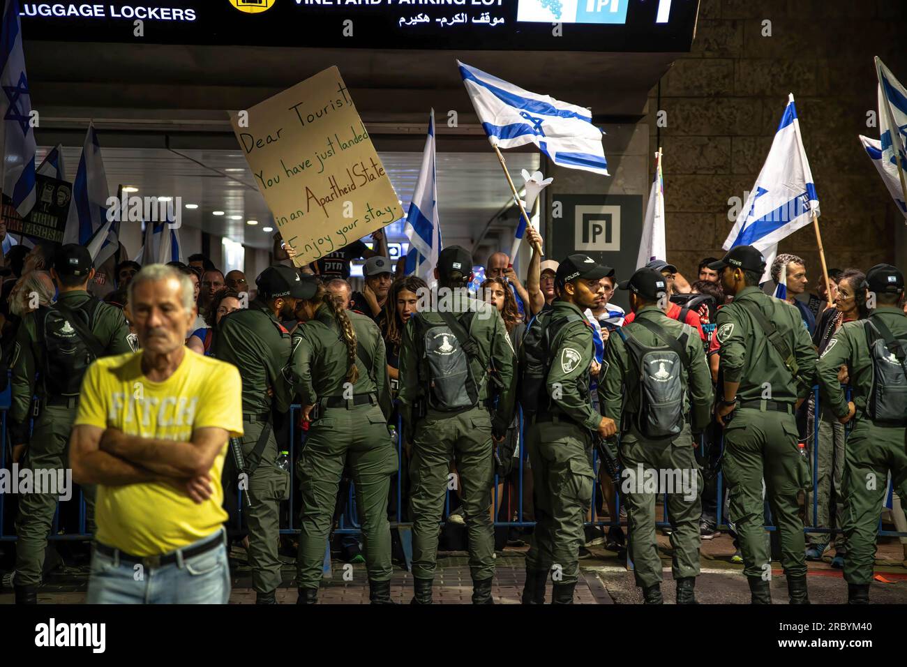 Israeli border police officers line up in front of protesters waving ...