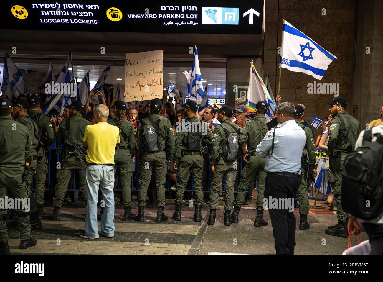 Israeli border police officers line up in front of protesters waving ...