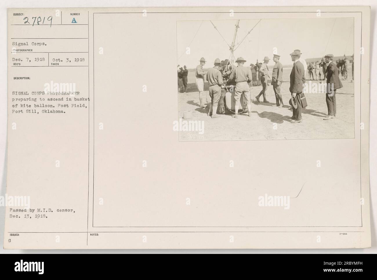A Signal Corps photographer prepares to ascend in a basket of a kite ...