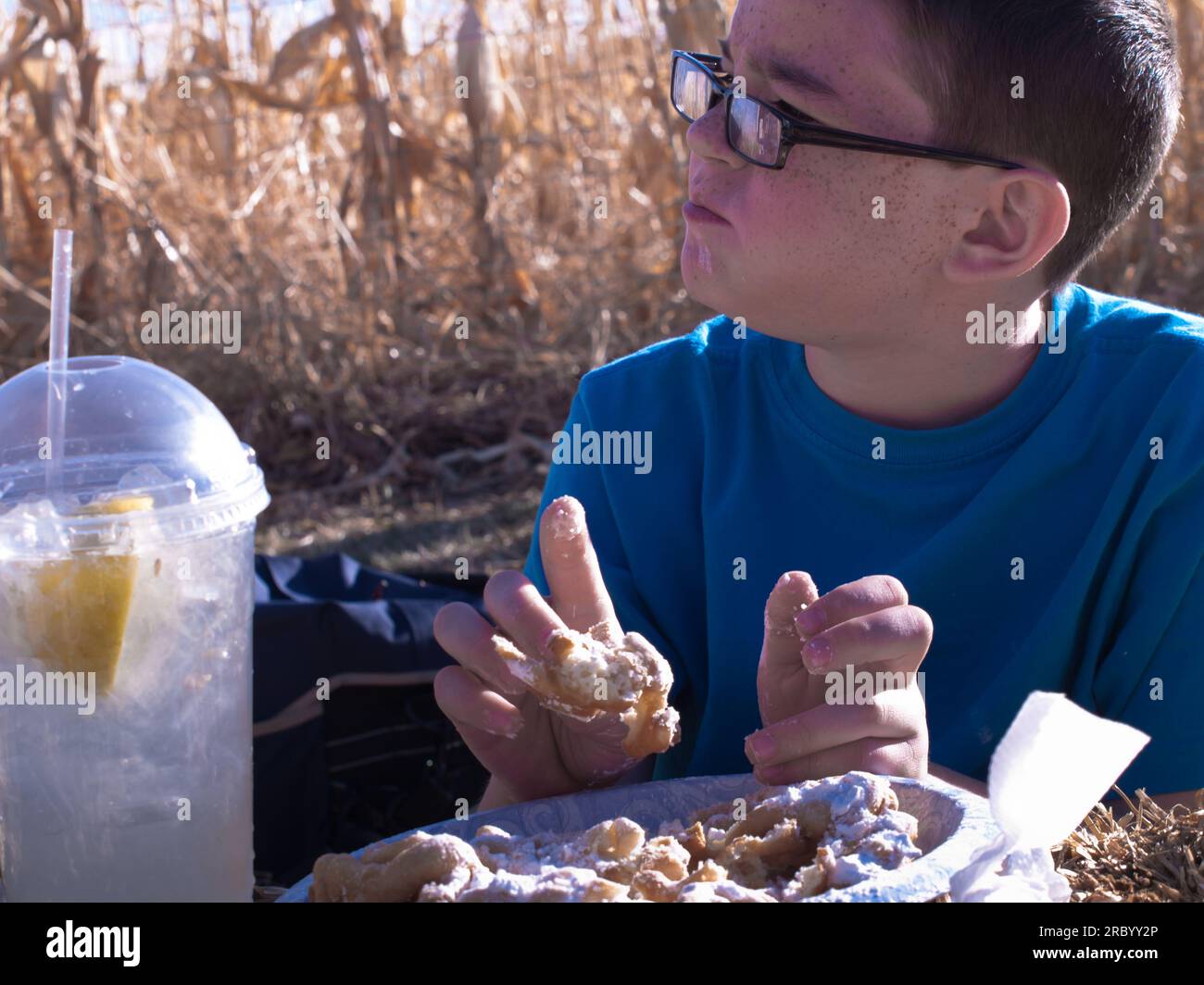 Young Boy Eating Funnel Cake Stock Photo - Alamy
