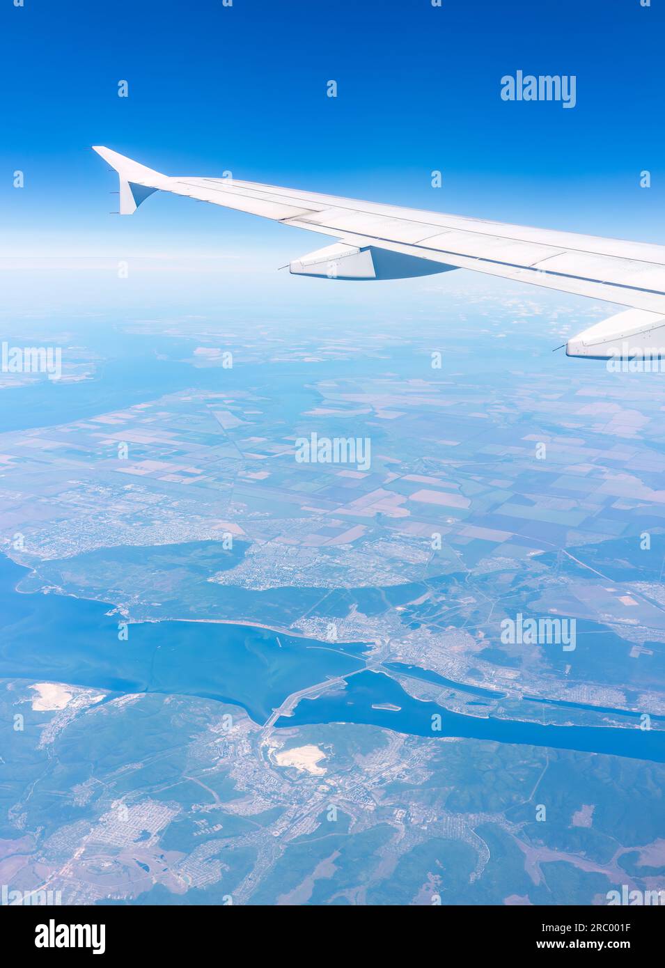 Aerial view from airplane window above green ground. View from the ...