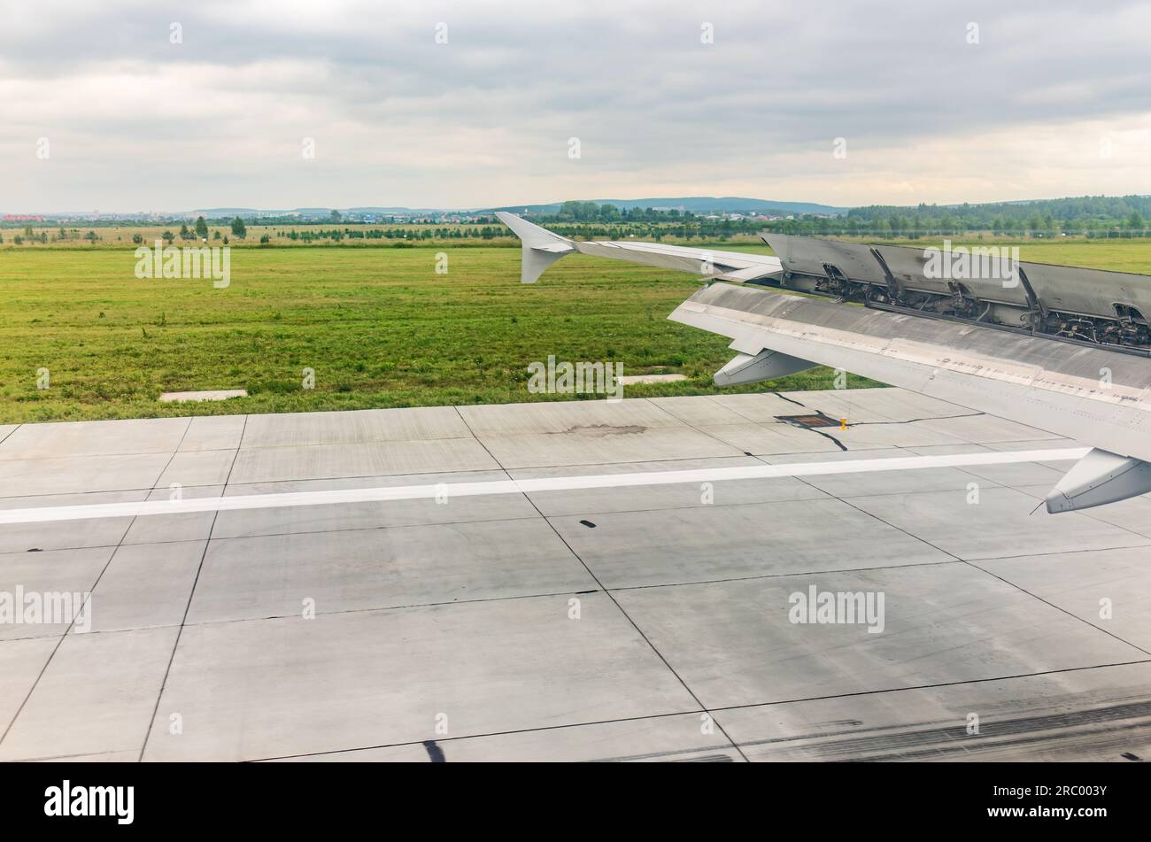View of airplane wing, blue skies and green land during landing ...