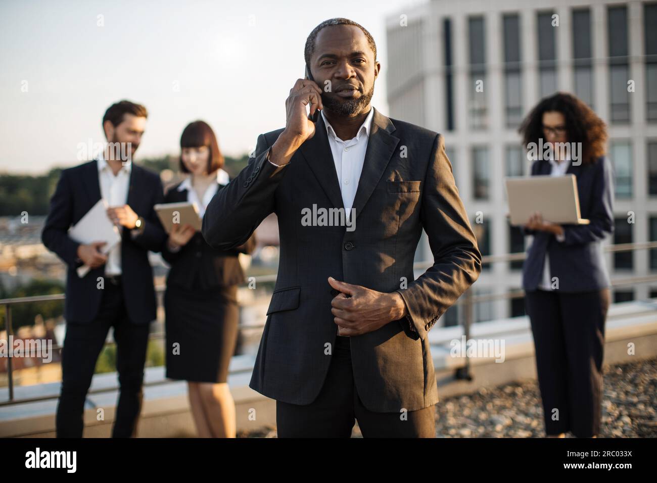 Beaming african american gentleman having conversation on smartphone ...