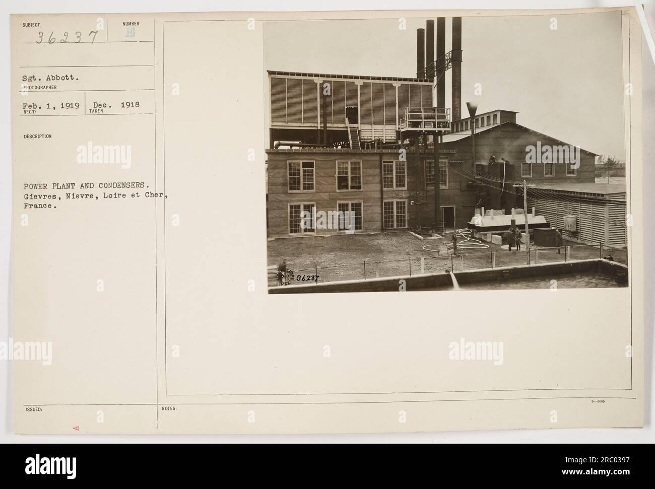 Image shows Sgt. Abbott in front of a power plant and condensers in ...
