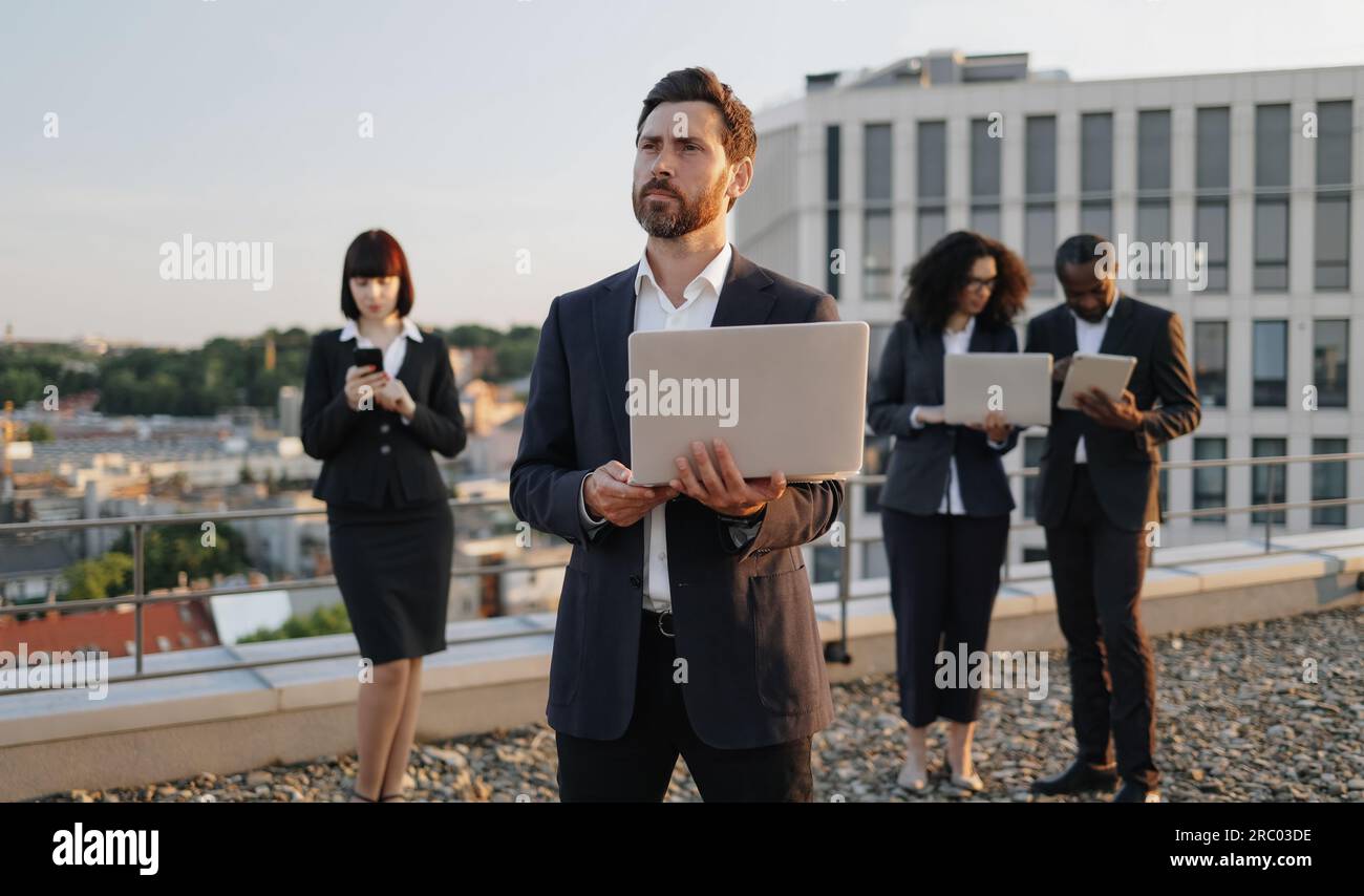 Good-looking caucasian businessman sending email from wireless computer ...