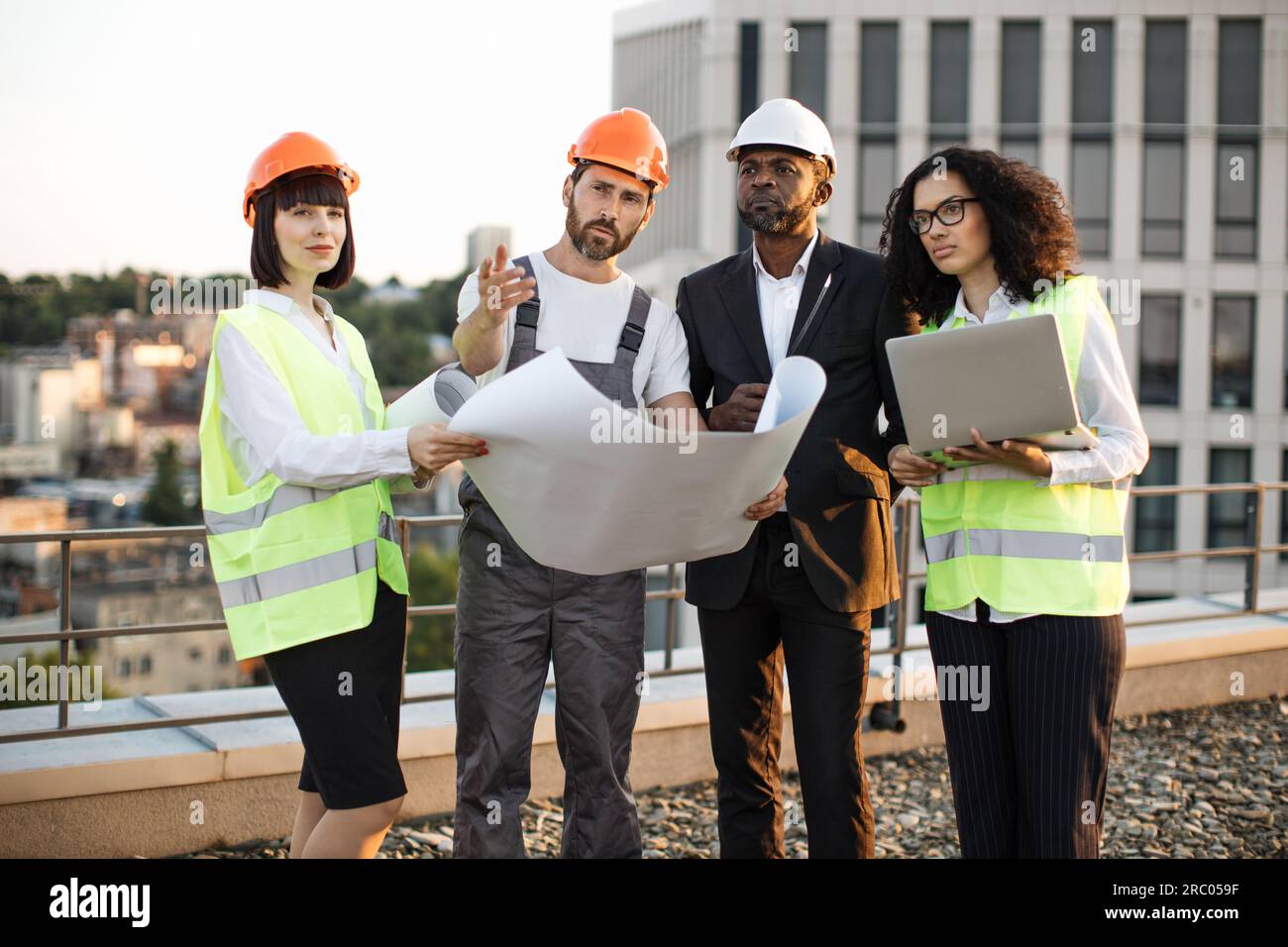 Group of multiethnic industrial employees planning building project and ...