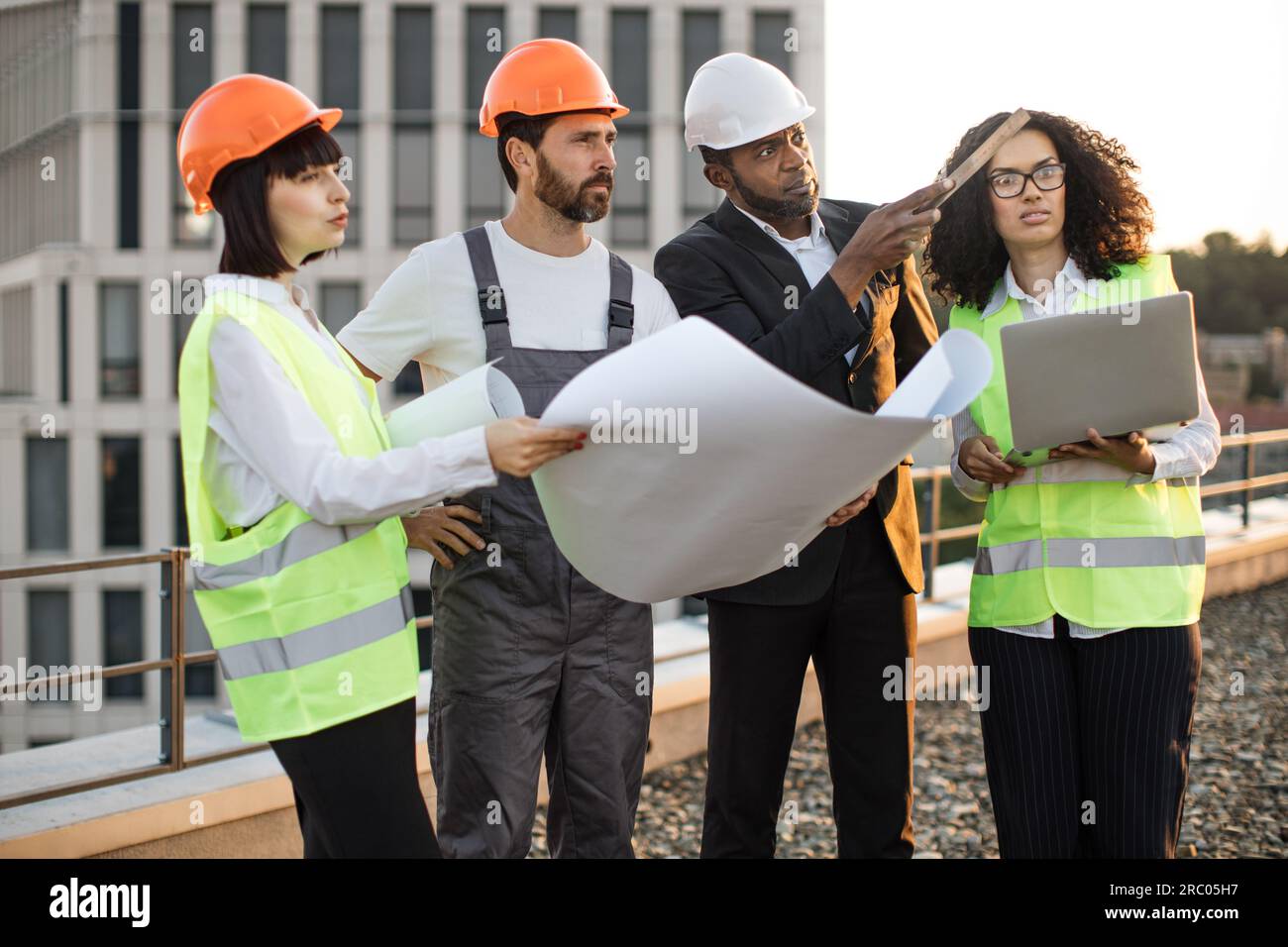 Group of multiethnic industrial employees planning building project and ...
