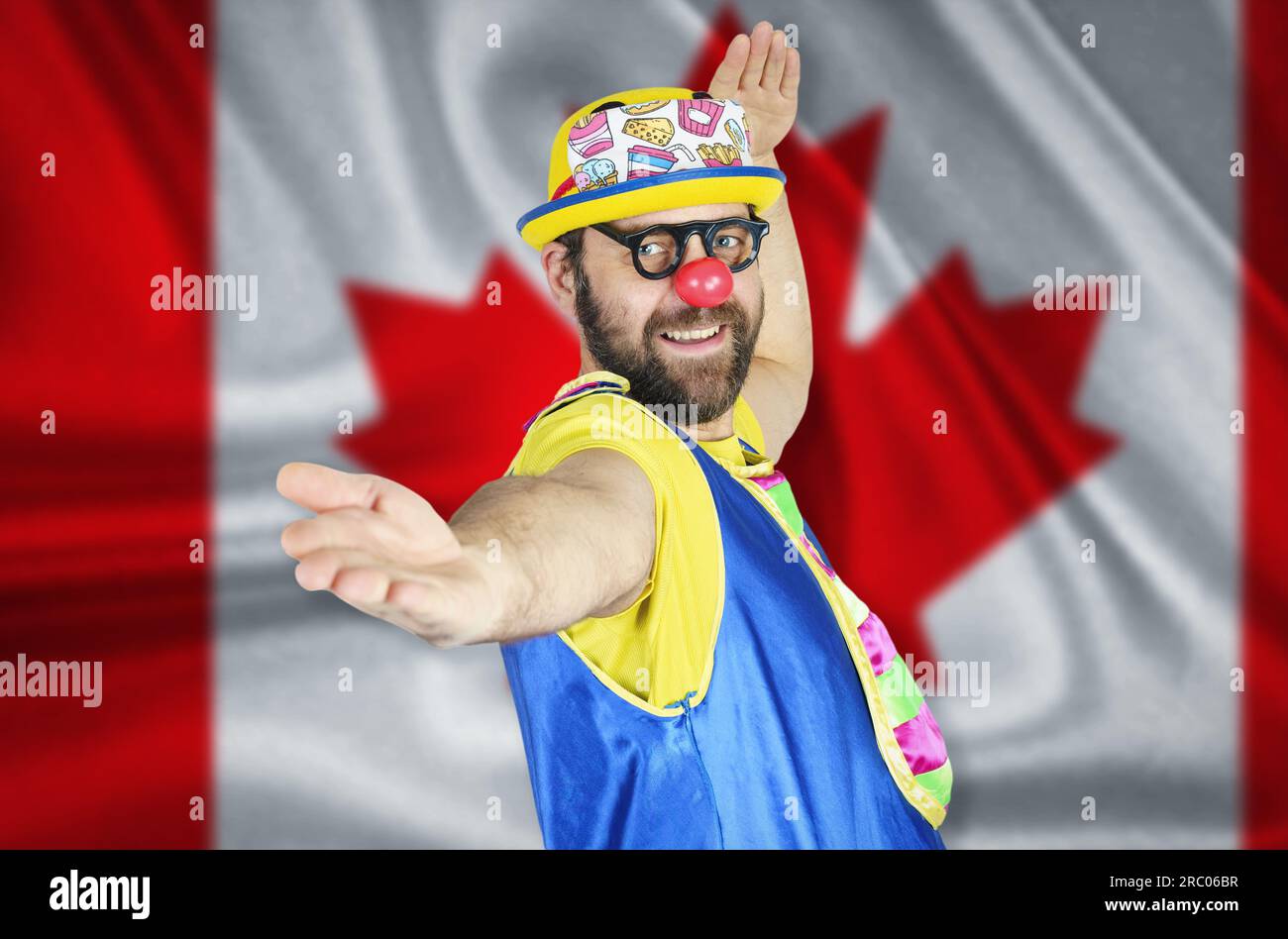 A cheerful clown stands in a welcoming pose against the background of ...