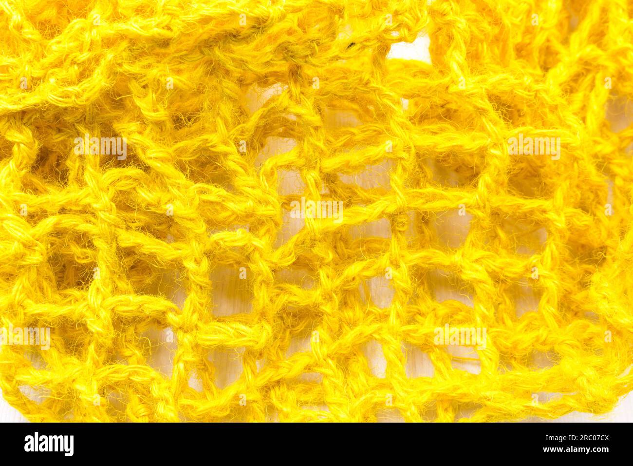 Knitted fabric made of yellow jute, mesh. Close-up. Background Stock ...