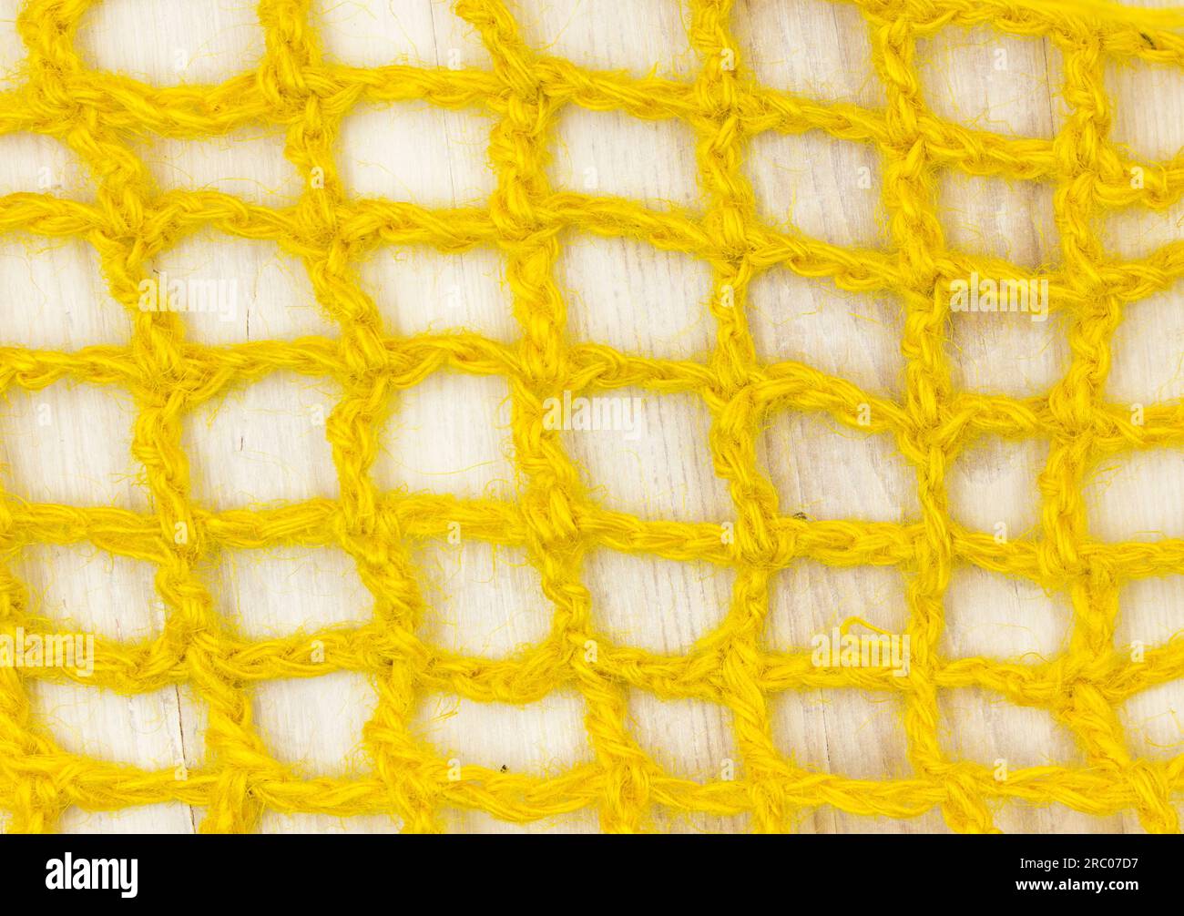 Knitted fabric made of yellow jute, mesh. Close-up. Background Stock ...