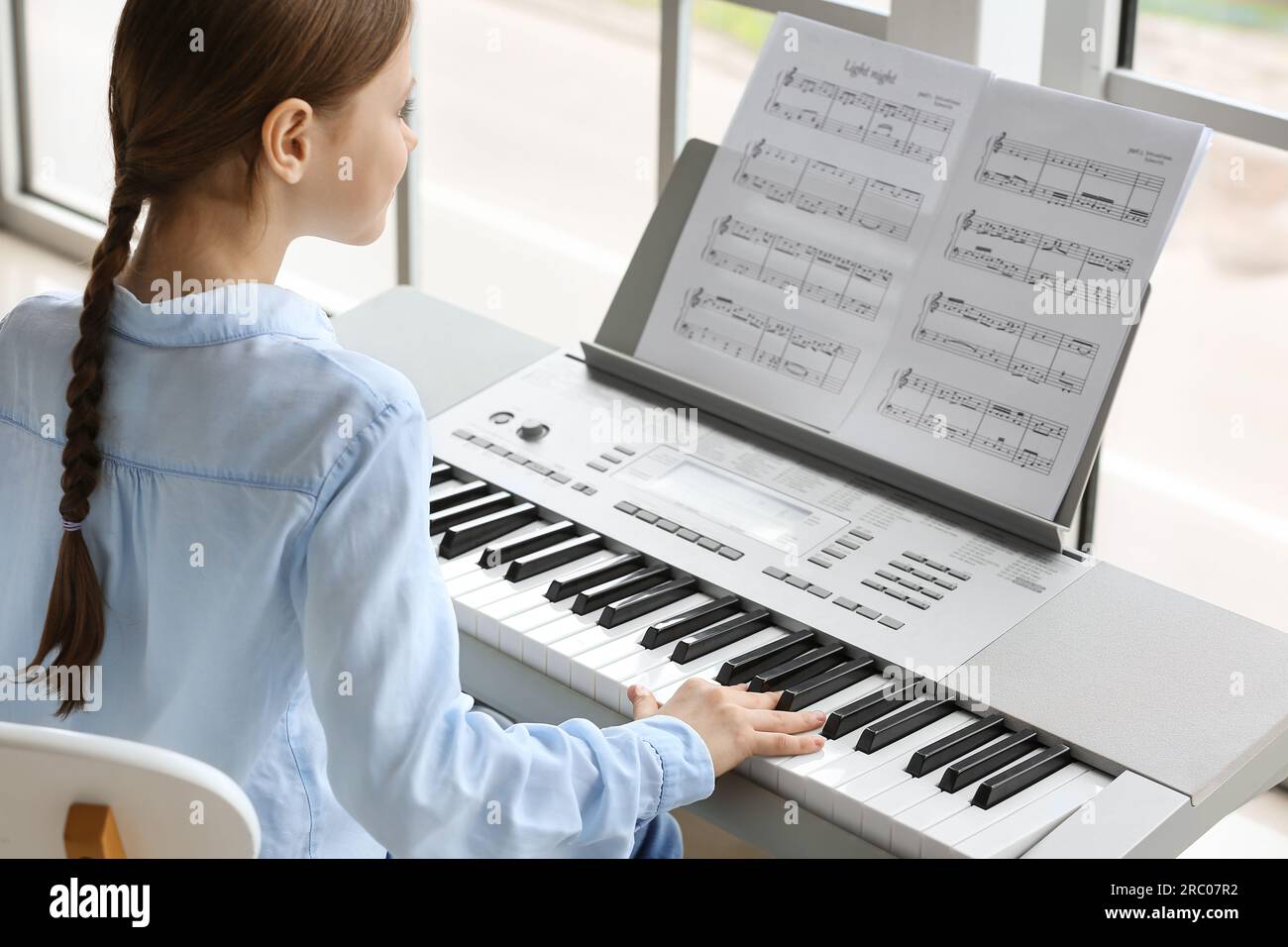 Little girl playing synthesizer at home Stock Photo - Alamy