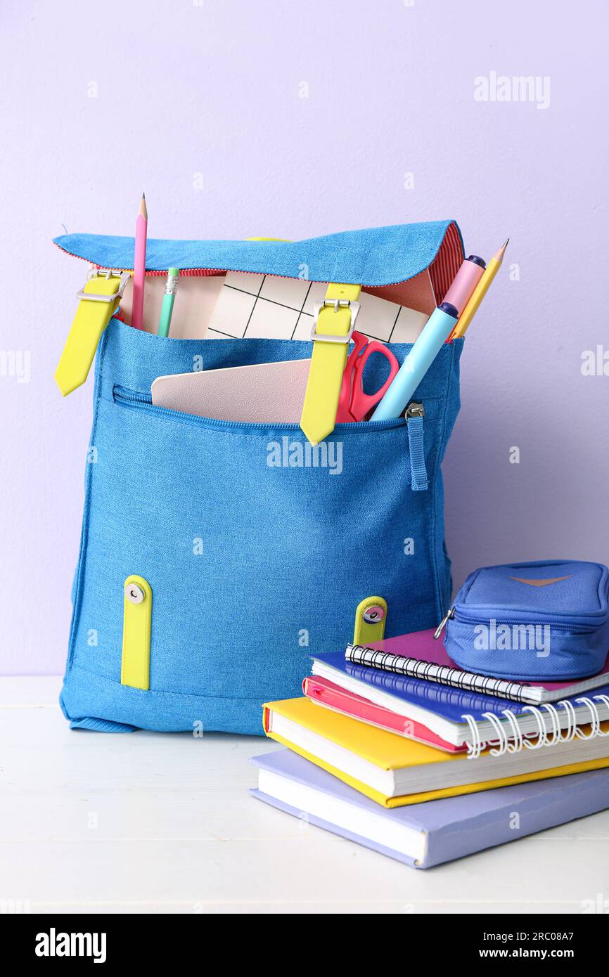 Blue school backpack with books, pencil case and markers on white ...