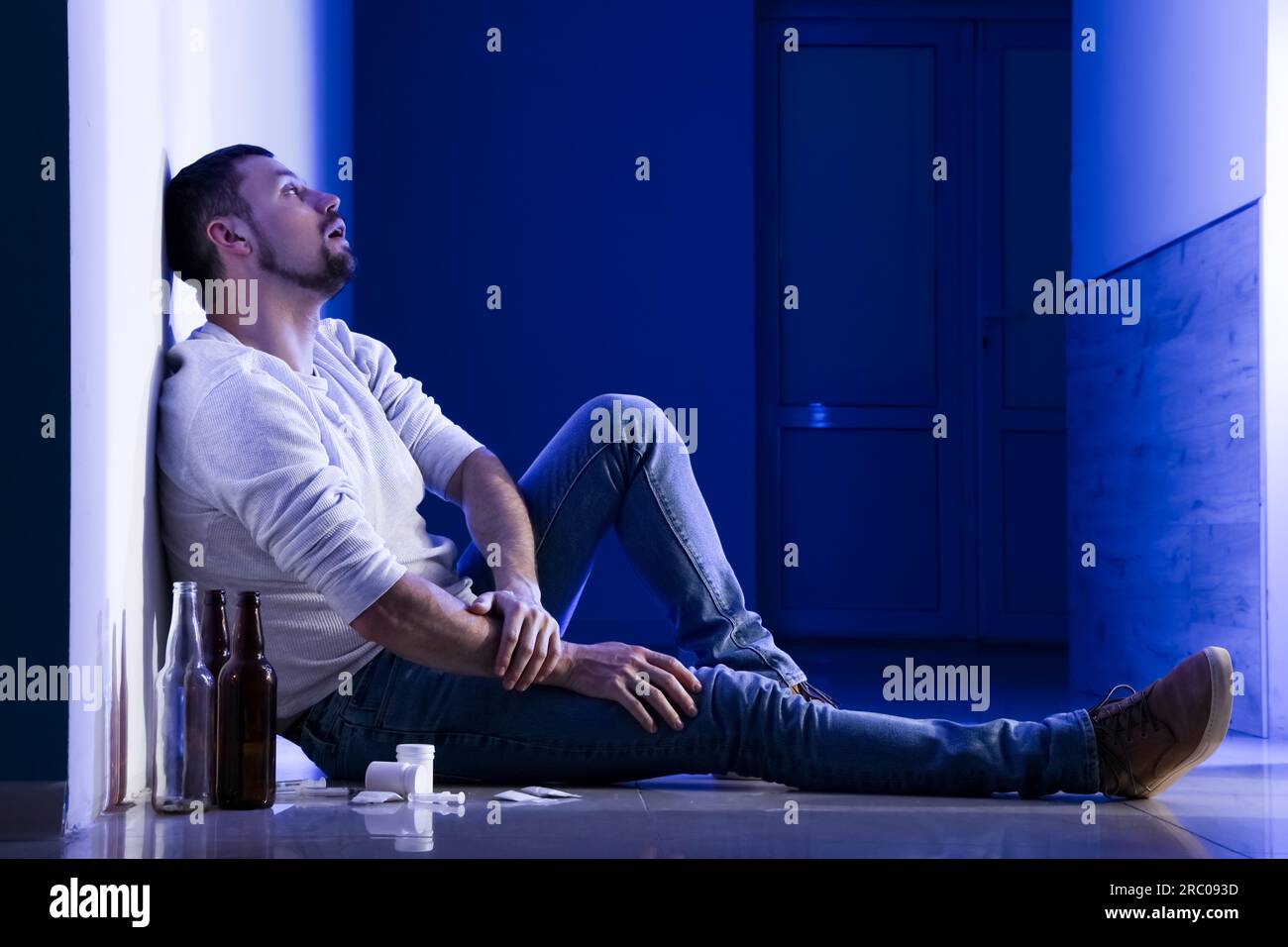 Male drug addict sitting in hall Stock Photo - Alamy