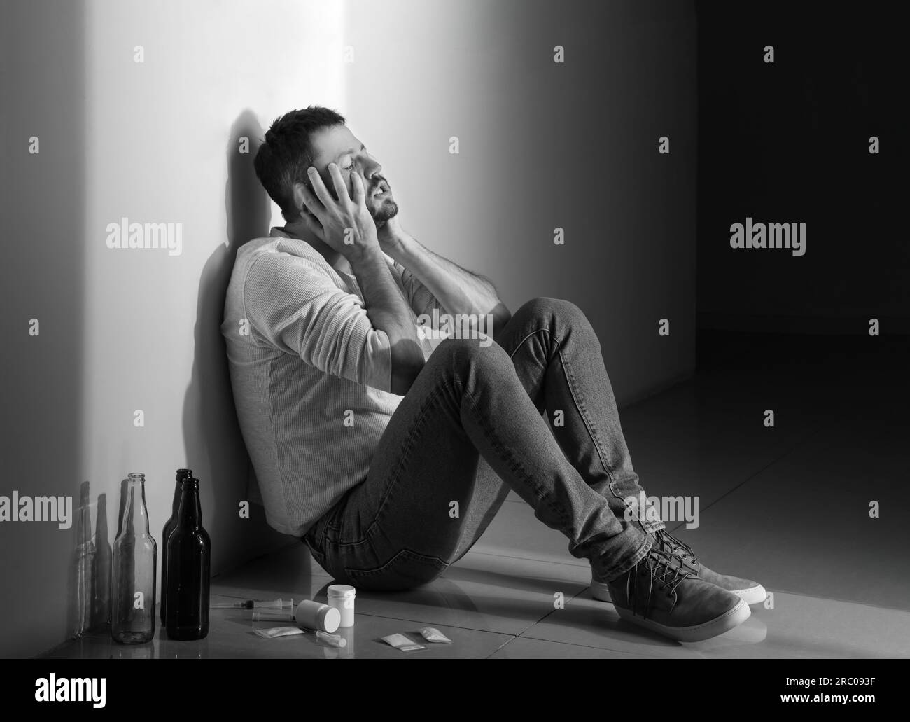 Male junkie with drugs sitting in hall Stock Photo - Alamy