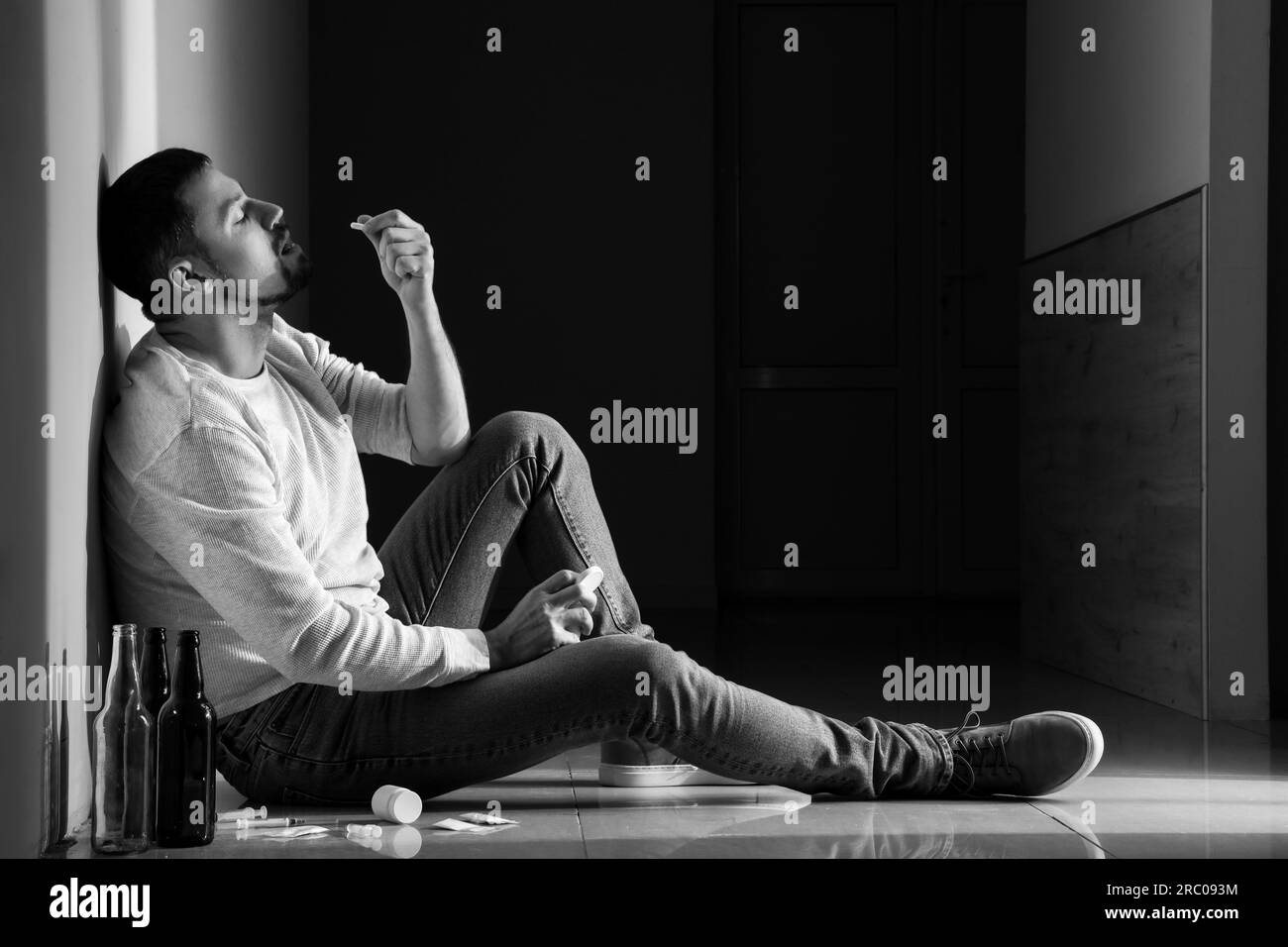 Male drug addict taking pill in hall Stock Photo - Alamy