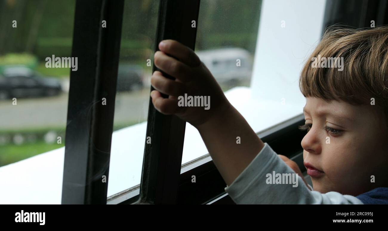 Baby child tries to open window kid trying to slide window Stock Photo ...