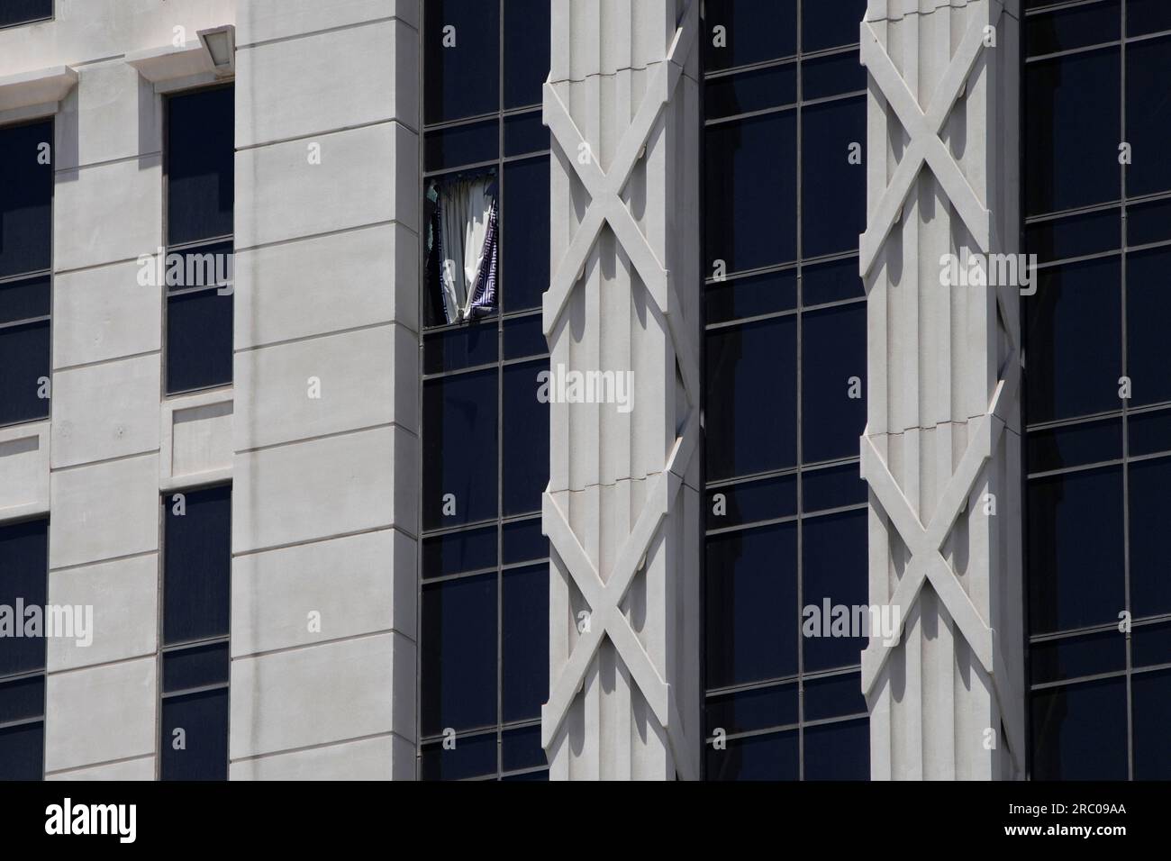 A curtain hangs out of a broken window on a hotel tower at Caesars ...