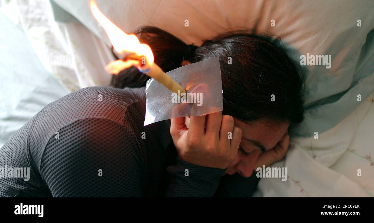 Person applying ear candling to remove ear wax Stock Photo - Alamy