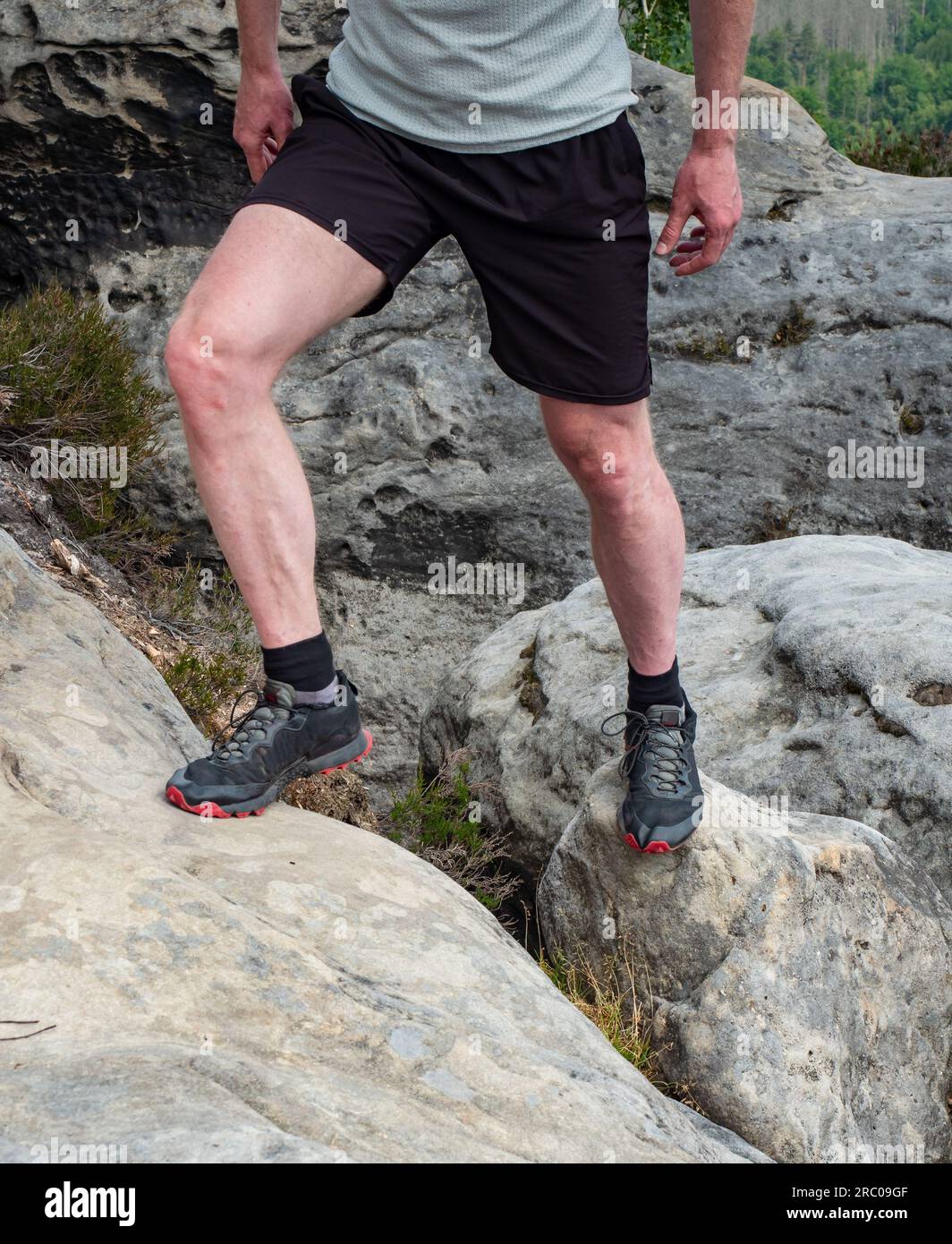 Detail of hiker legs in black red hiking boots on mountain summit. Feet ...