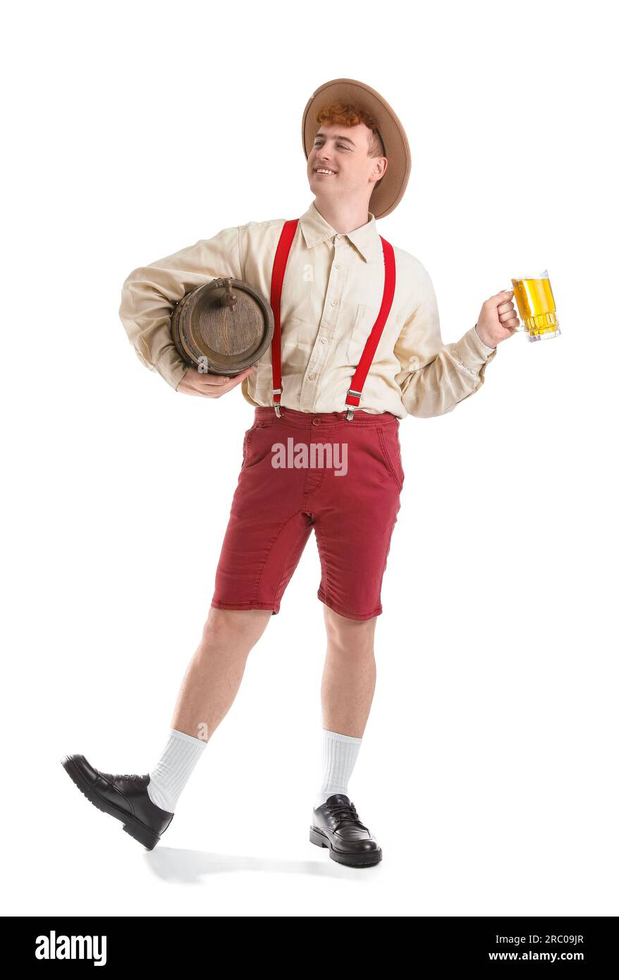 Young man in traditional German clothes with beer on white background ...