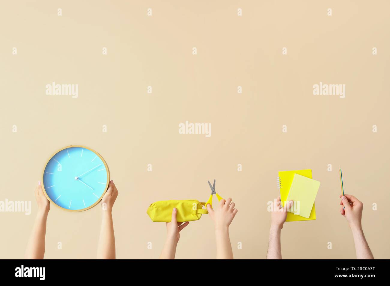 Many hands holding school supplies on beige background Stock Photo - Alamy