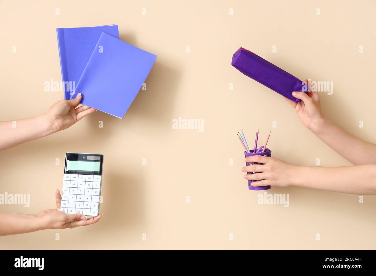 Female hands holding school supplies on beige background Stock Photo ...