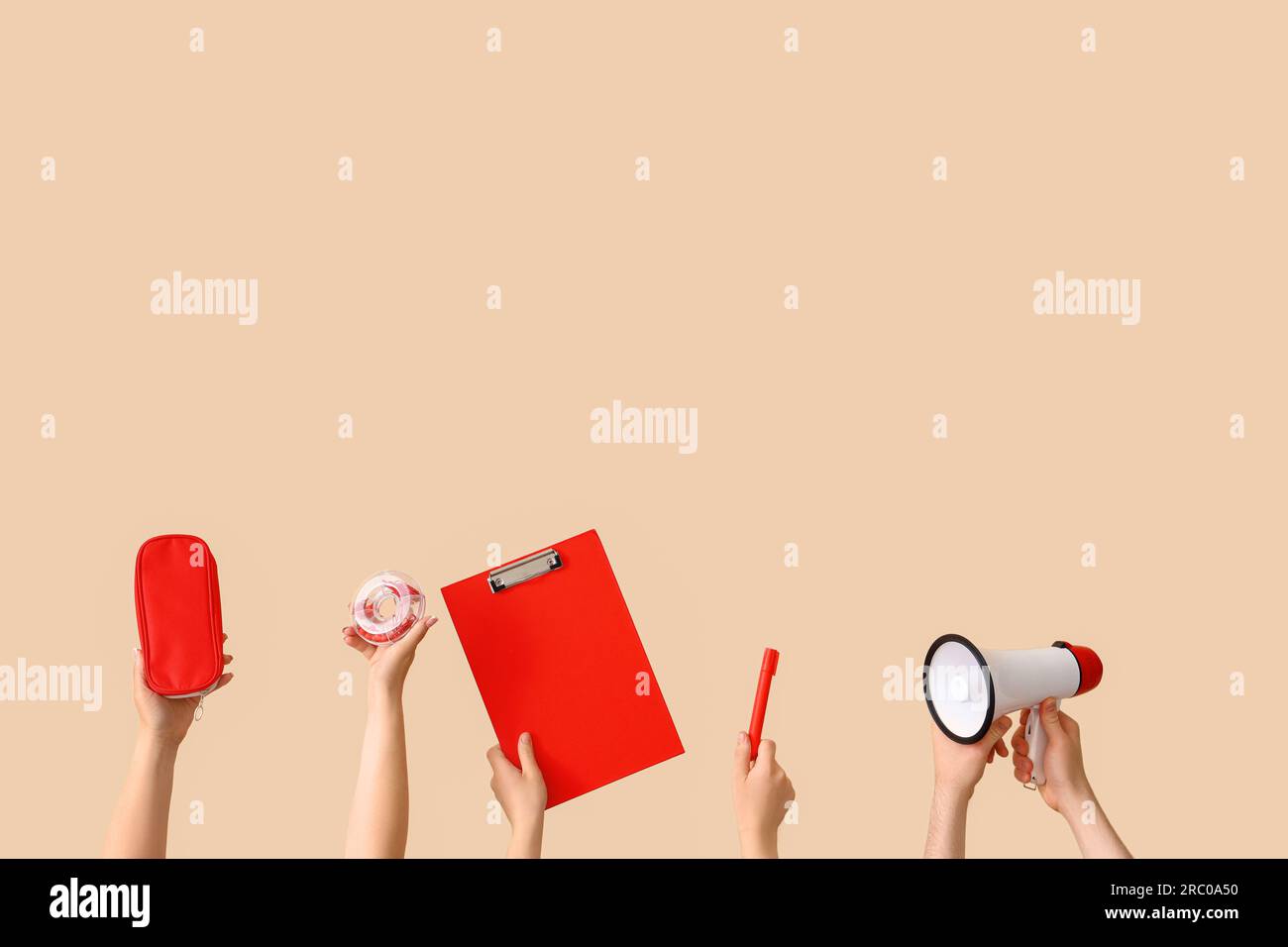 Many hands holding school supplies on beige background Stock Photo - Alamy