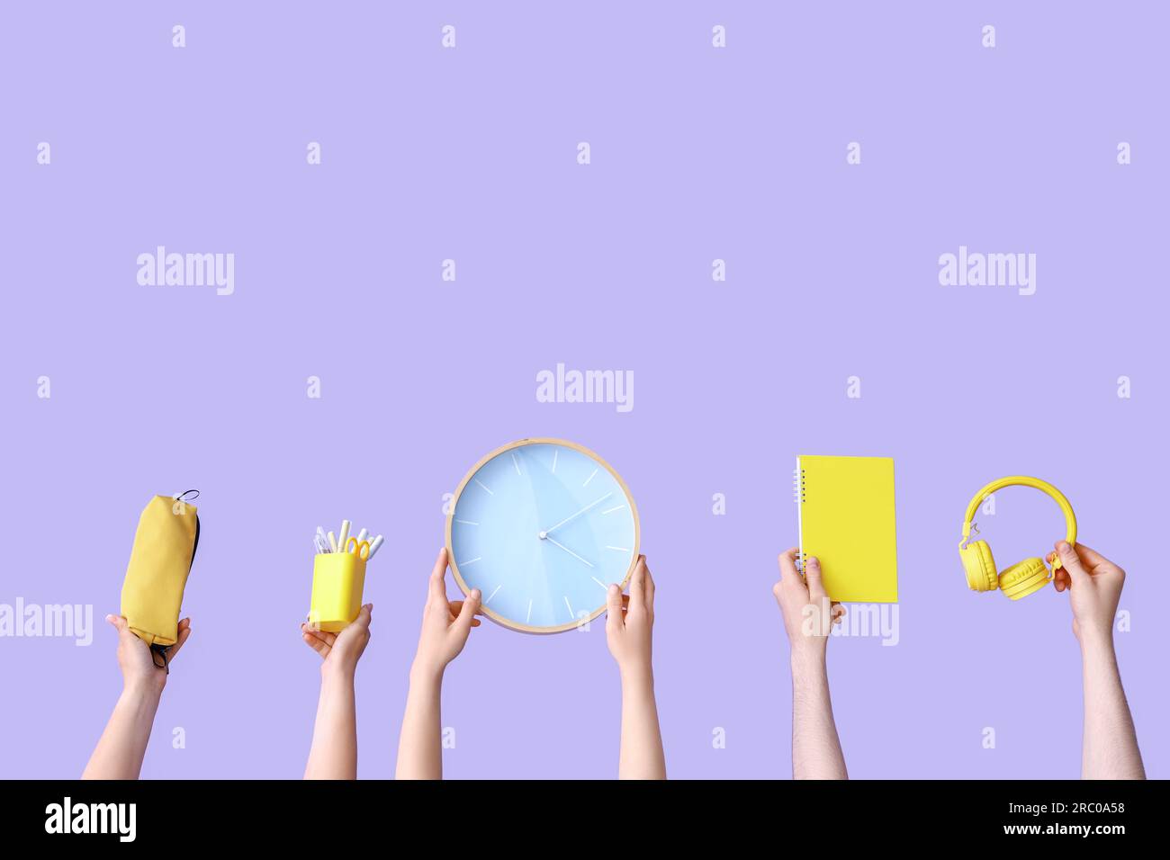 Many hands holding school supplies on lilac background Stock Photo - Alamy
