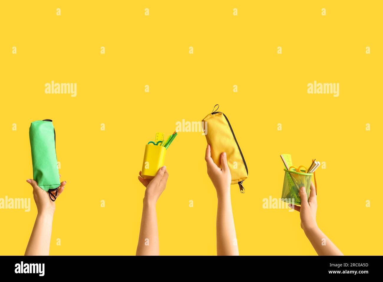 Female hands holding school supplies on yellow background Stock Photo ...