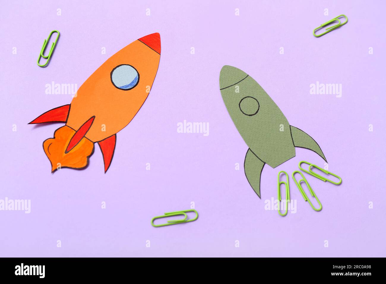Paper rockets with clips on purple background Stock Photo - Alamy
