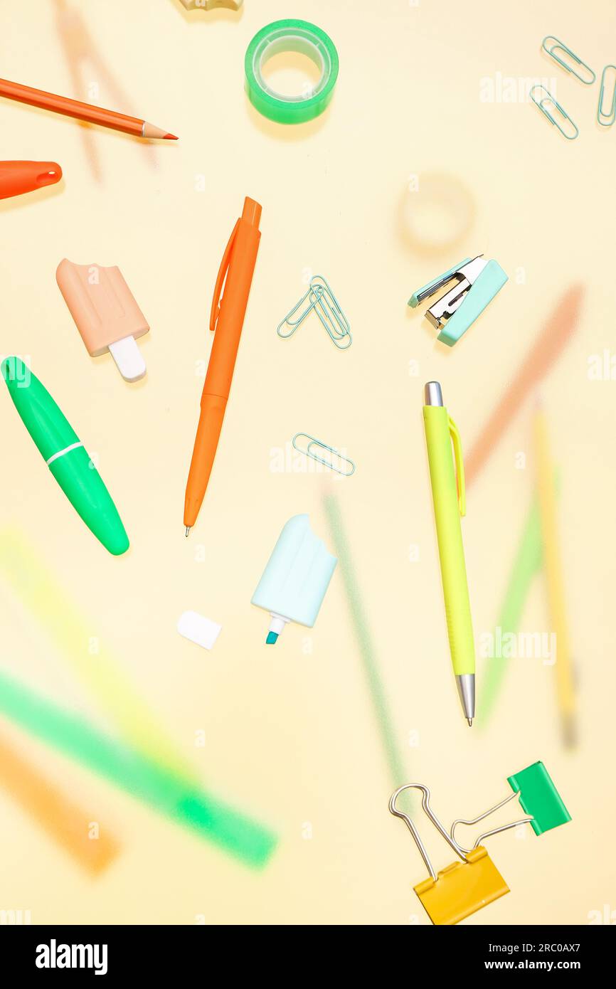 Different stationery on pale yellow background Stock Photo - Alamy