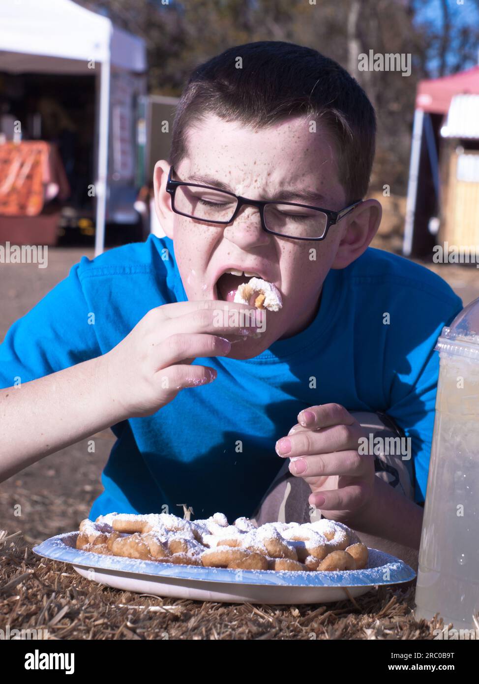 Young Boy Eating Funnel Cake Stock Photo - Alamy