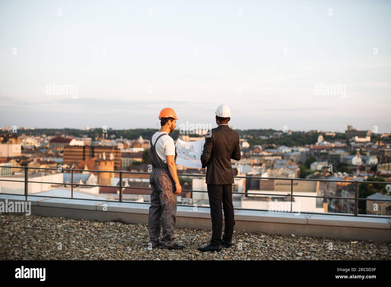 Back view of foreman in grey uniform and business investor in black ...