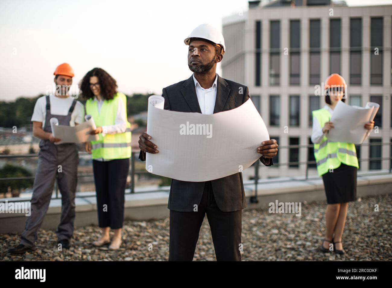 African american businessman wearing suit and hardhat holding project ...
