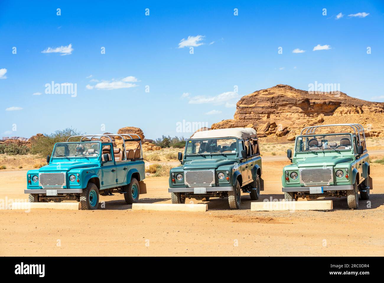 Off-road cars and desert cliffs formations landscape at Hegra, Al Ula ...